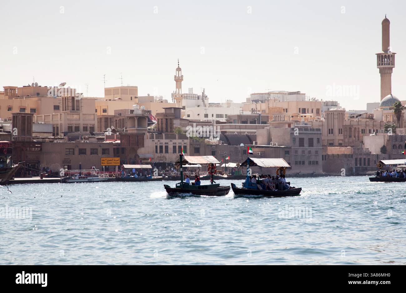 Traditional Abra ferries crossing Dubai Creek which divides the city ...