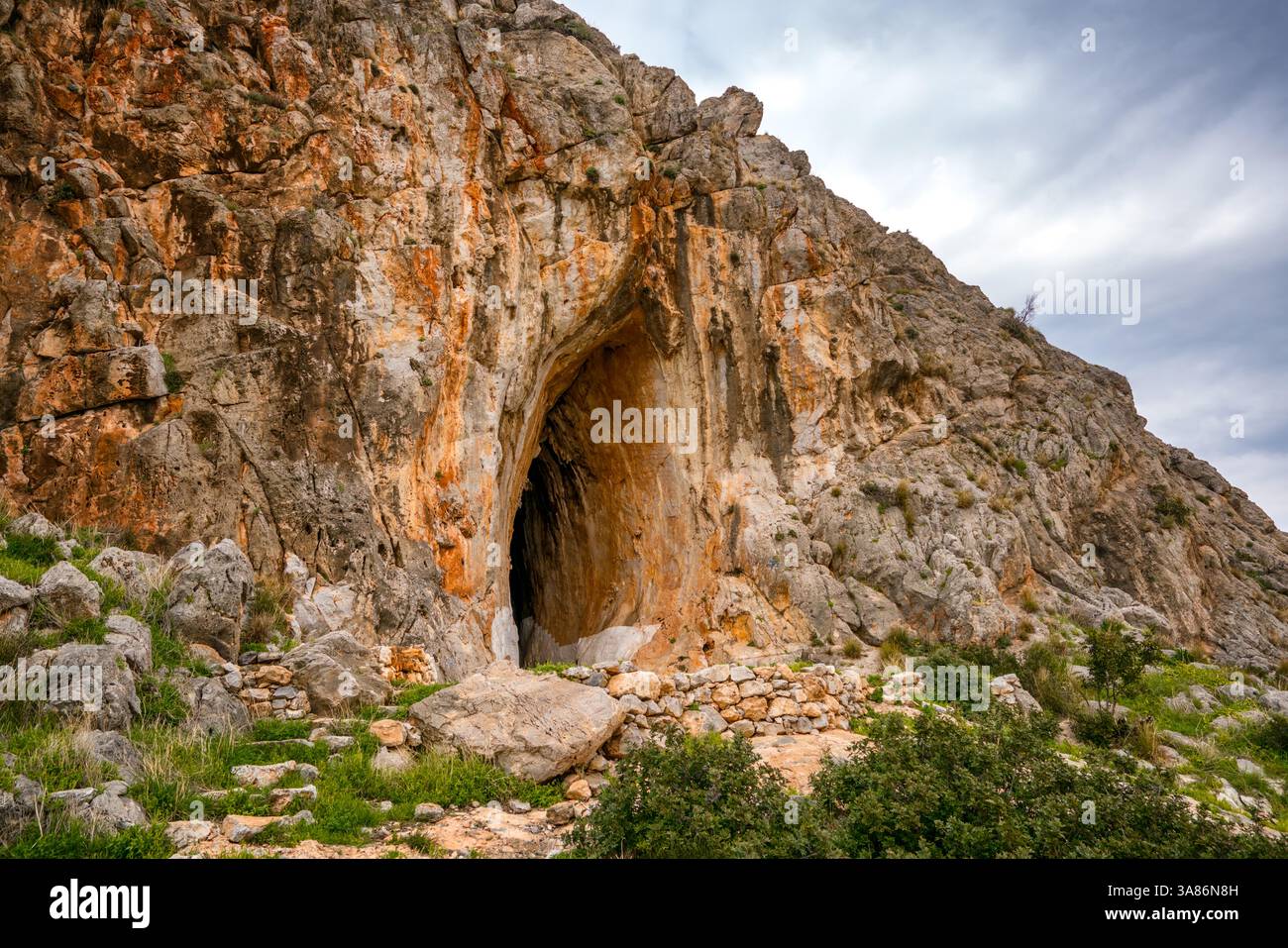 Cave of Elafonisos island with orange rock color painted in white ...