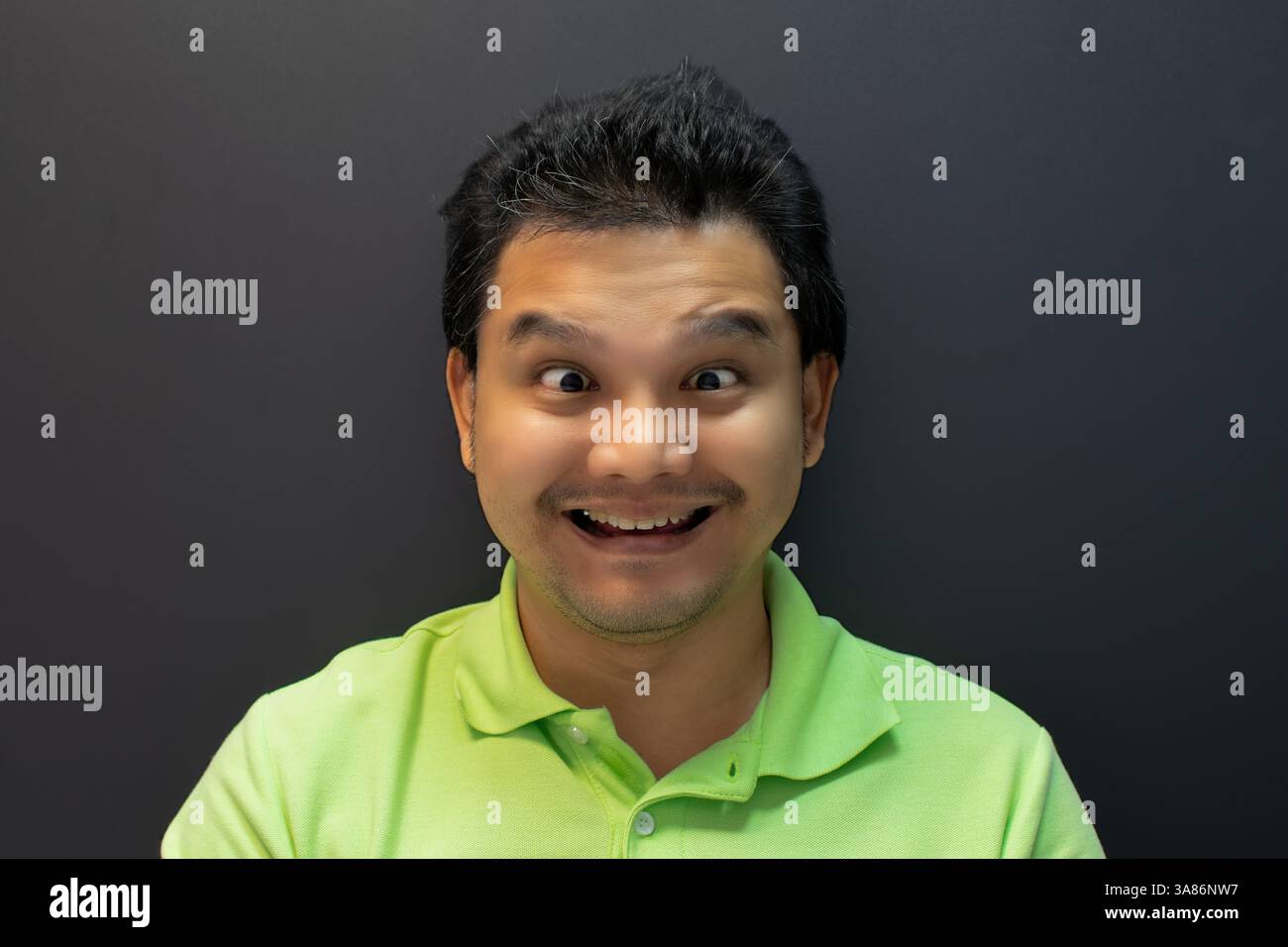 Asian man 40s smile have a crazy squinting gesture with confusion and ...