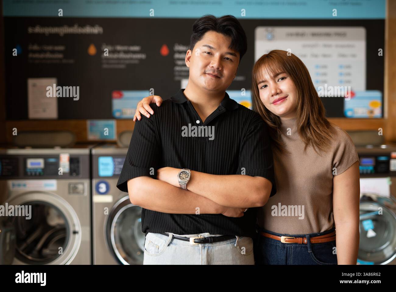 Young confident Asian couple in laundry shop Stock Photo - Alamy
