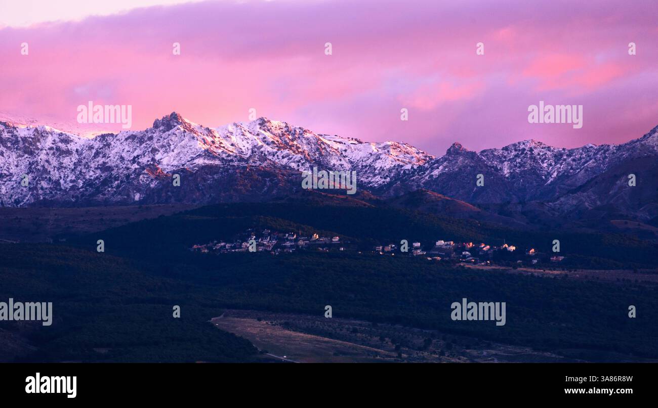 Dramatic purple sunset above snowy rugged summits of Los Cumbres Verdes ...