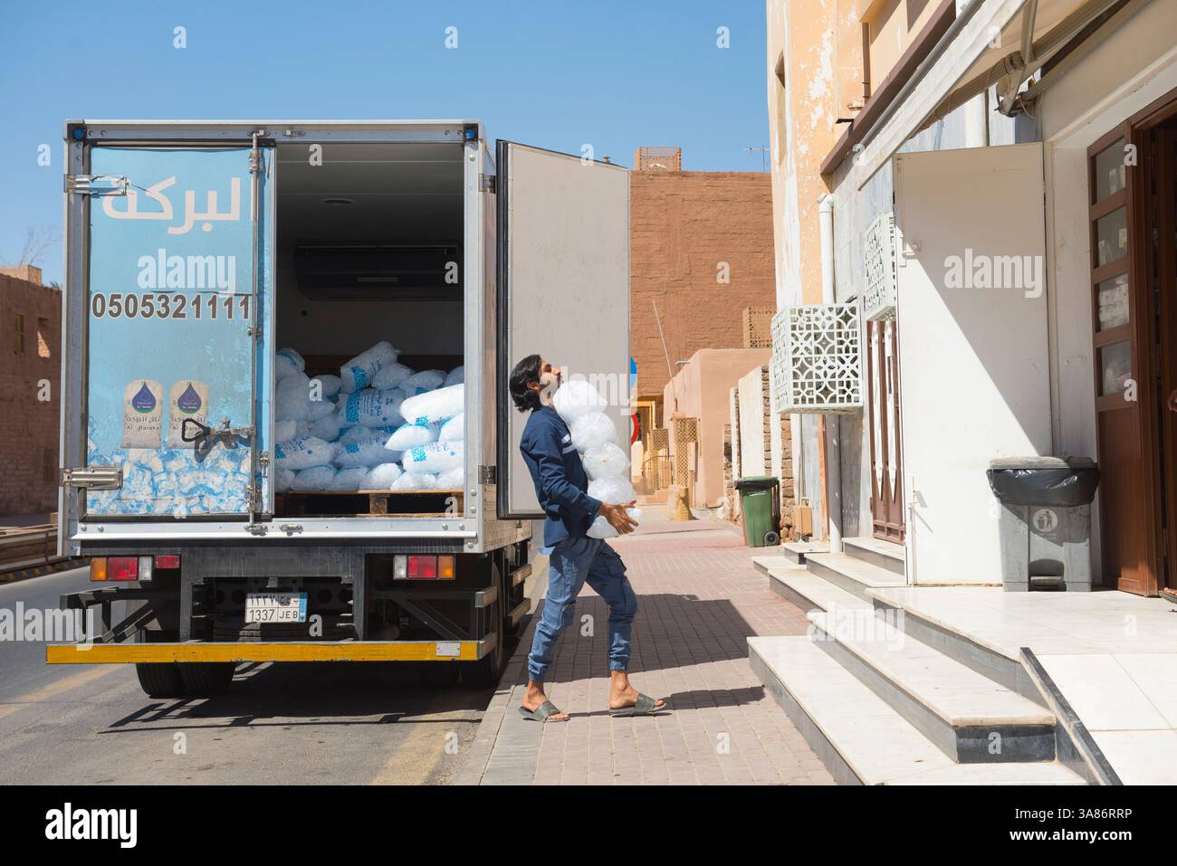 Man delivering ice packs in a street of the new city of AlUla, Medina ...