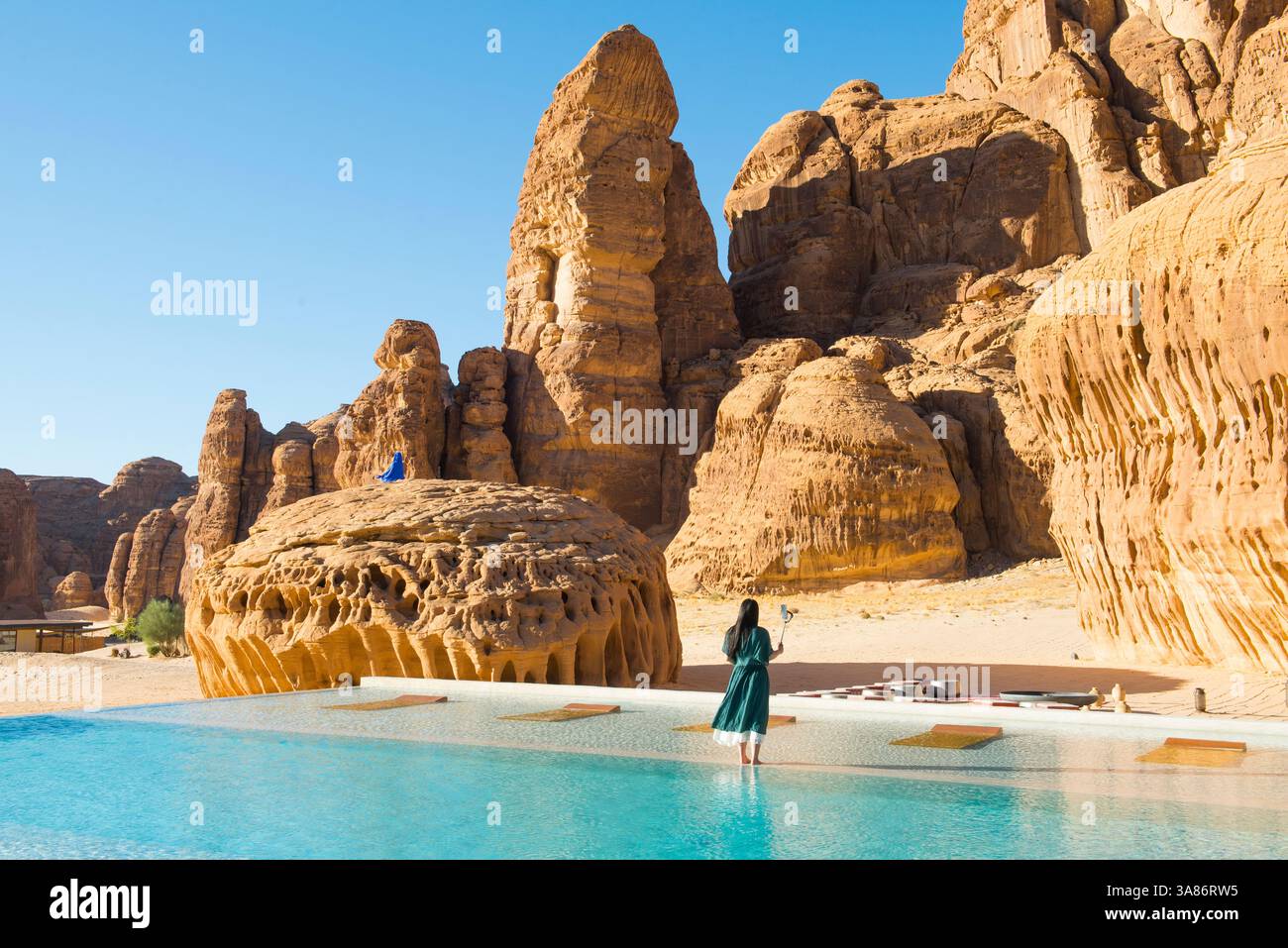 Woman by swimming pool, surrounded by sandstone rock structures, Our ...