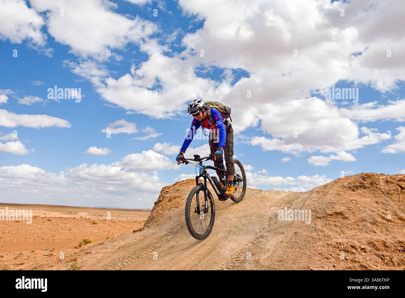 Electric mountain bike rider on track between Ouarzazate and Ait Ben Haddou, Ounila River valley ...