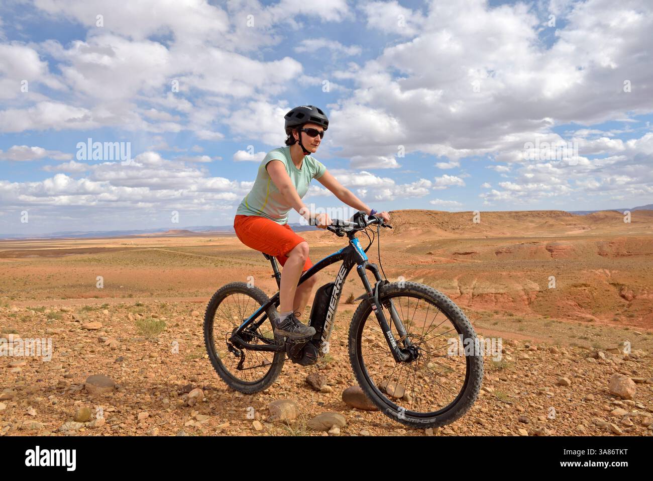 Electric mountain bike rider on track between Ouarzazate and Ait Ben Haddou, Ounila River valley ...