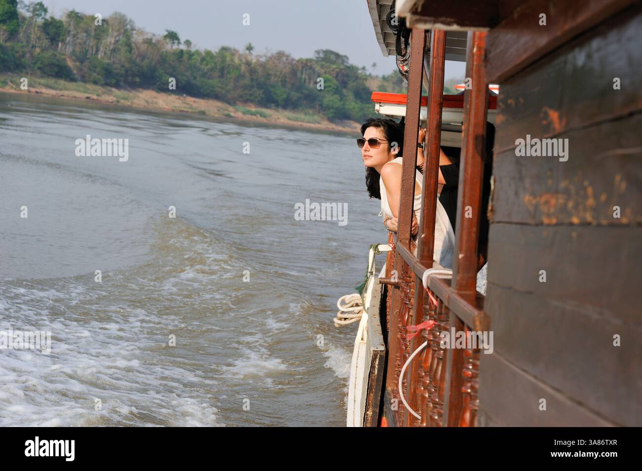 Young woman standing at the railing of The Luang Say Lodge and Cruises cruise boat on Mekong ...