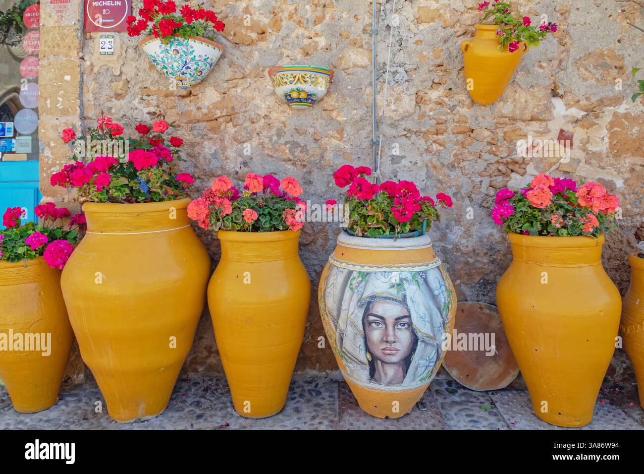 Traditional handmade glazed clay pots filled with flowers, Marzameni ...