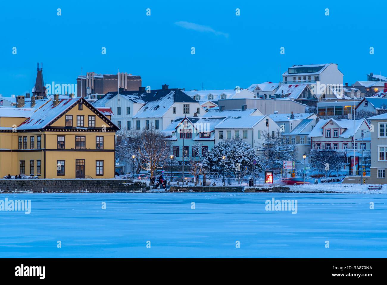 View of the city skyline of Reykjavik from Tjornin lake at sunset in ...