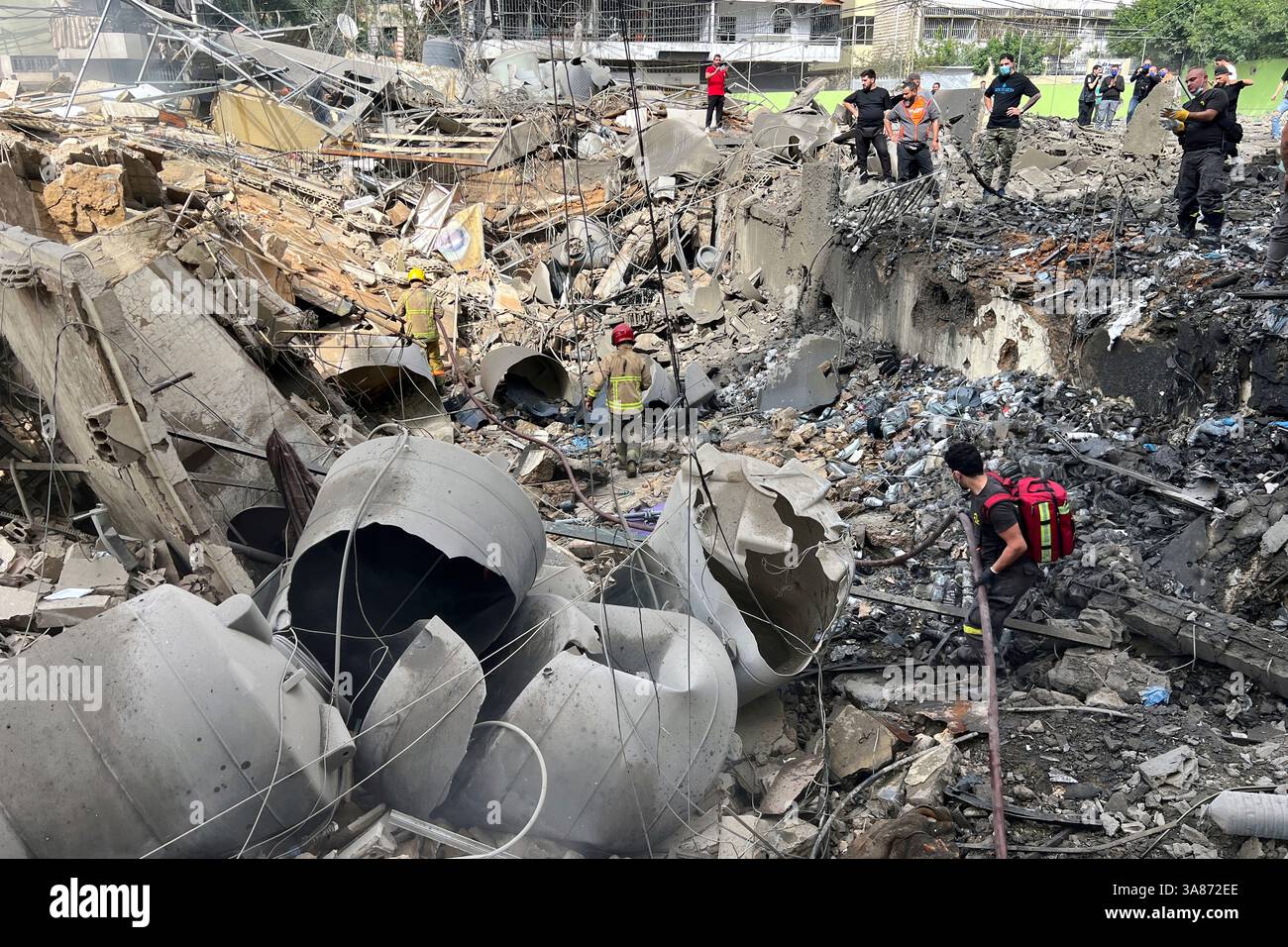 Firemen work on the site of an Israeli army strike in the suburb of ...