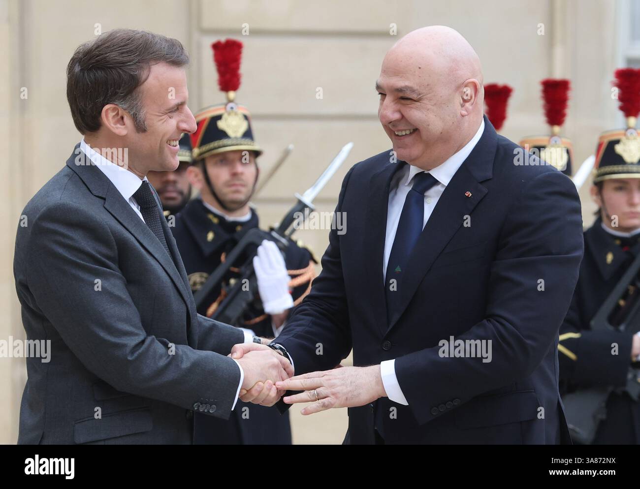 French President Emmanuel Macron (L) greets his Lebanese counterpart ...