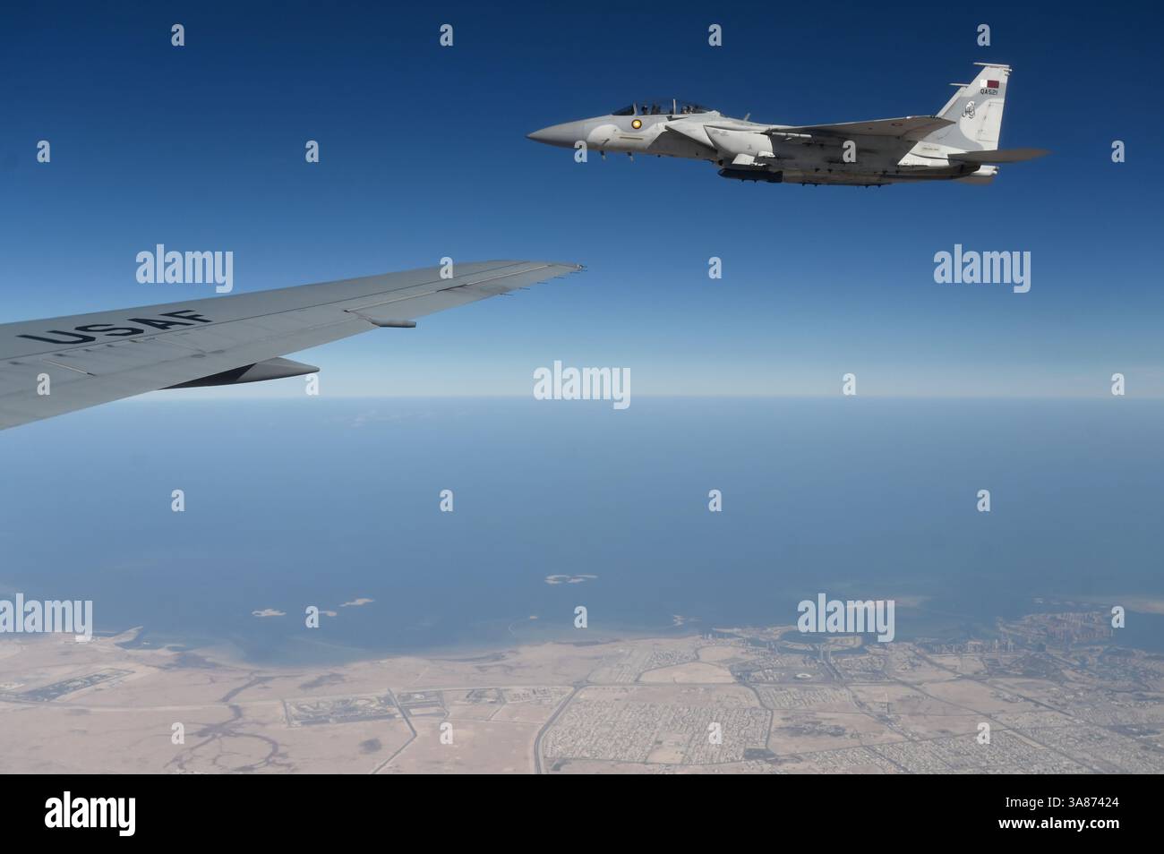 A Qatar Emiri Air Force F-15QA Ababil flies in formation with a U.S ...