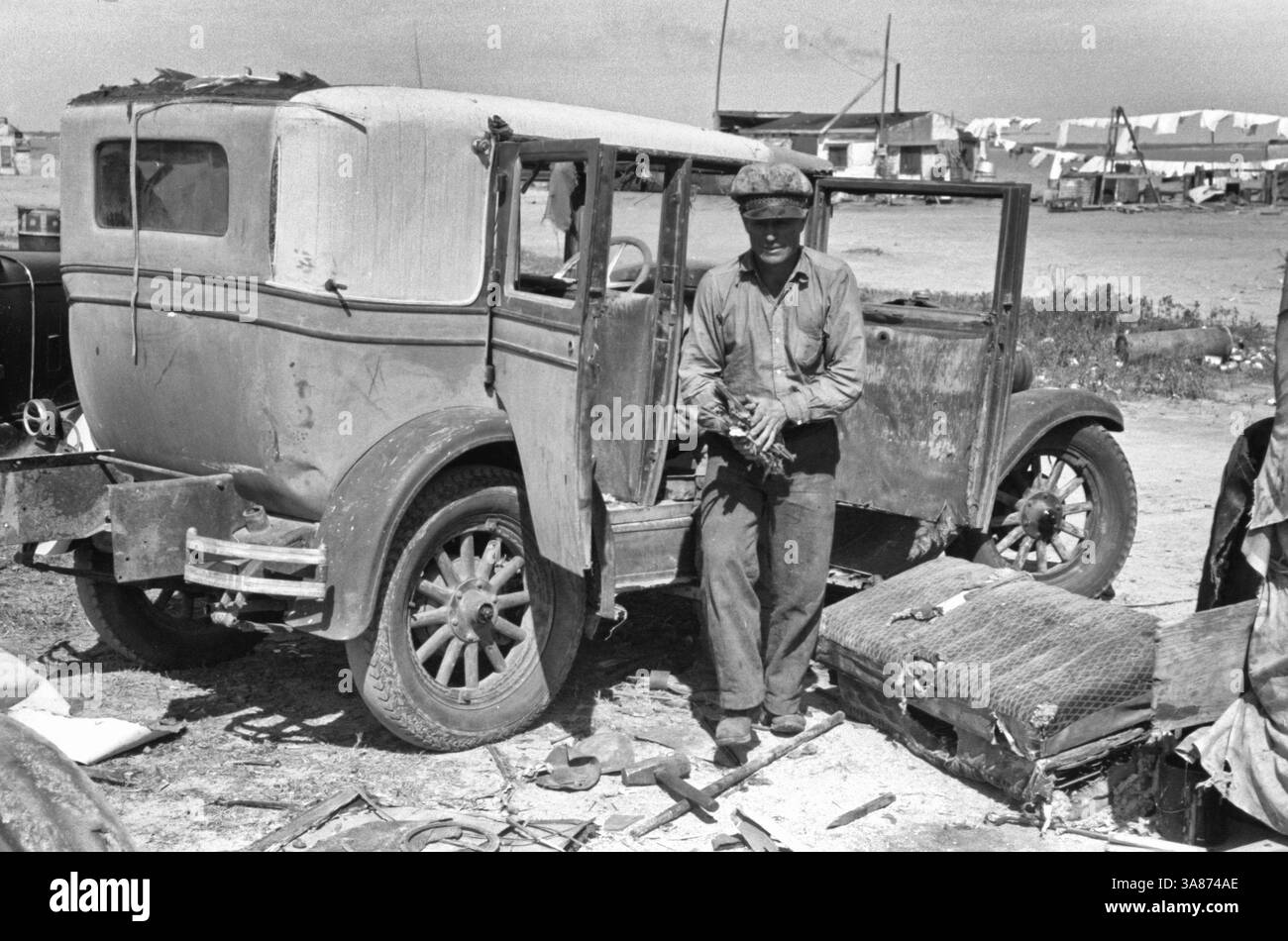 Migrant auto wrecker in front of car which he will dismantle, Corpus ...
