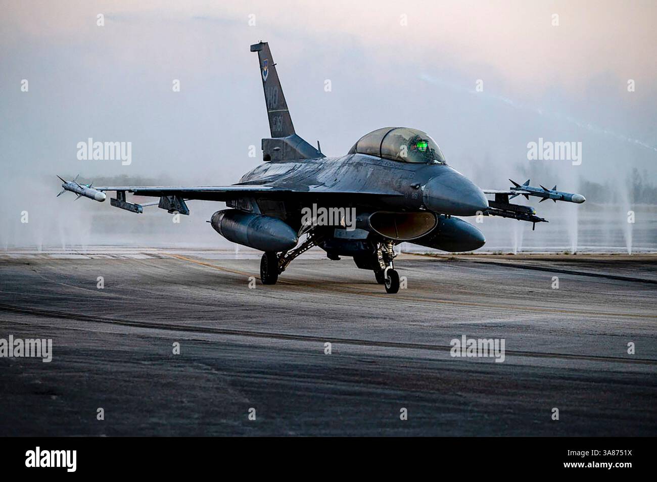 A U.S. Air Force F-16 Fighting Falcon runs through a bird bath for a ...
