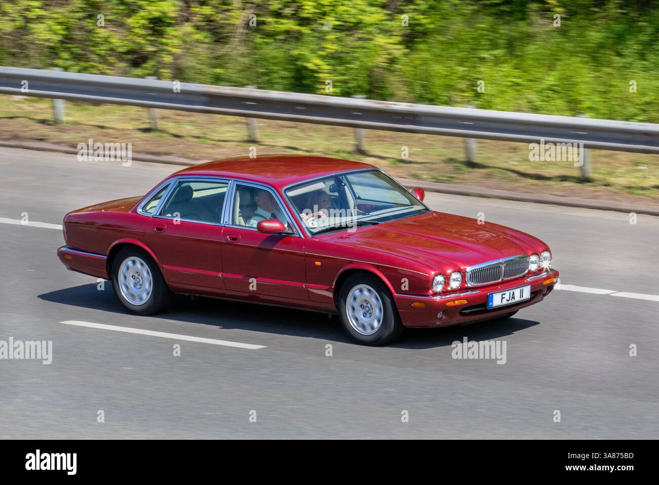 Red British Jaguar XJ Sovereign Tdvi Auto; travelling on the M61 ...
