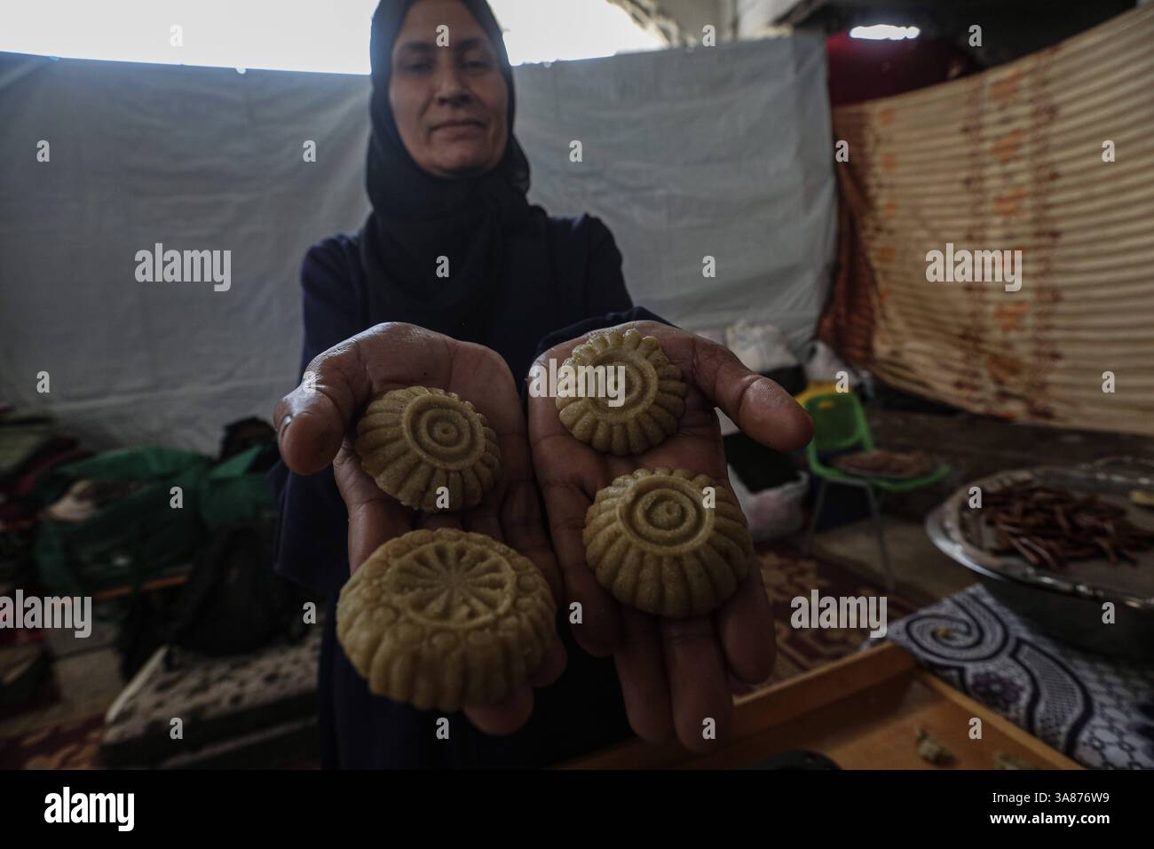 A Palestinian family prepares traditional cookies in preparation for ...