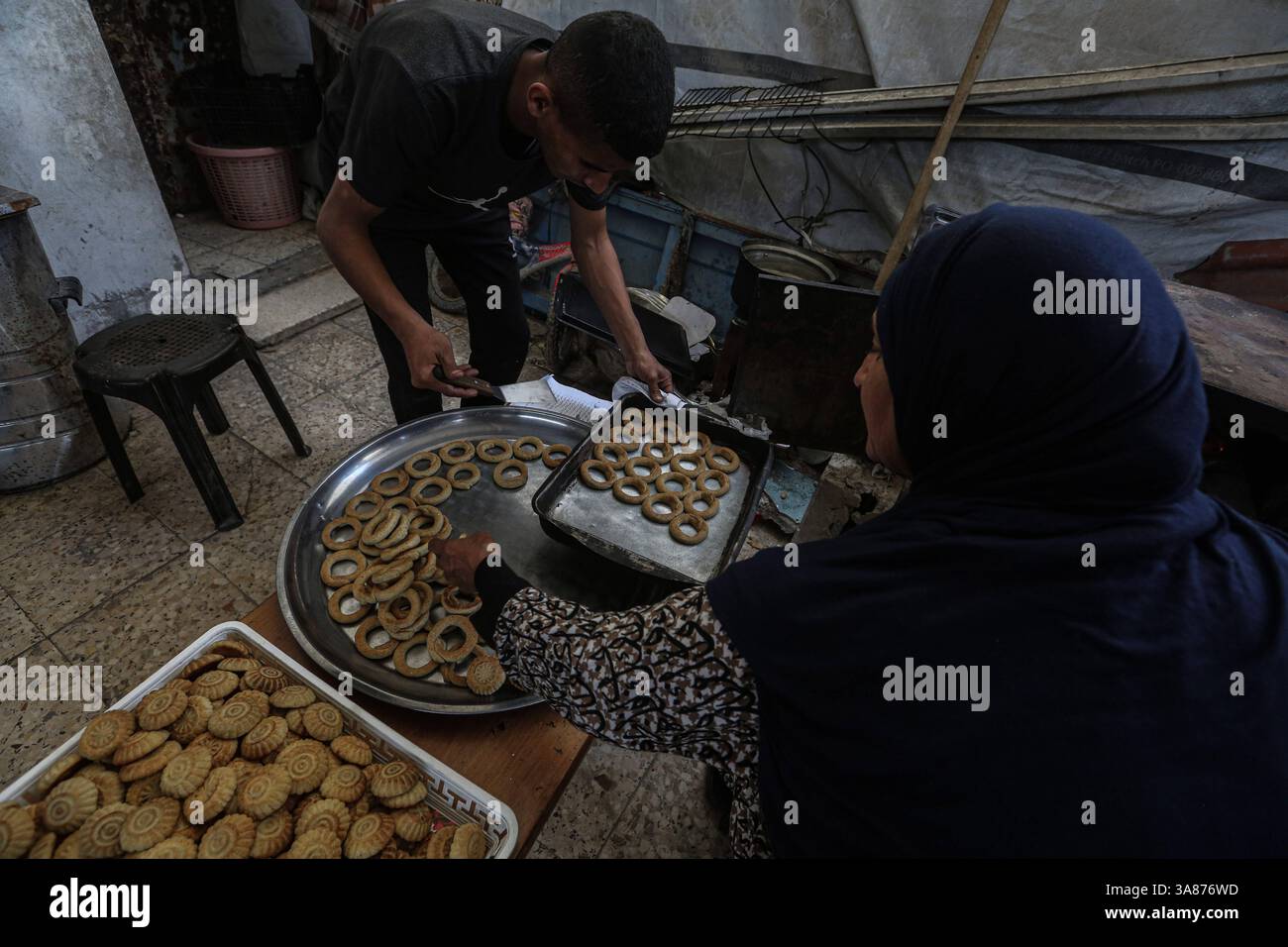 A Palestinian family prepares traditional cookies in preparation for ...