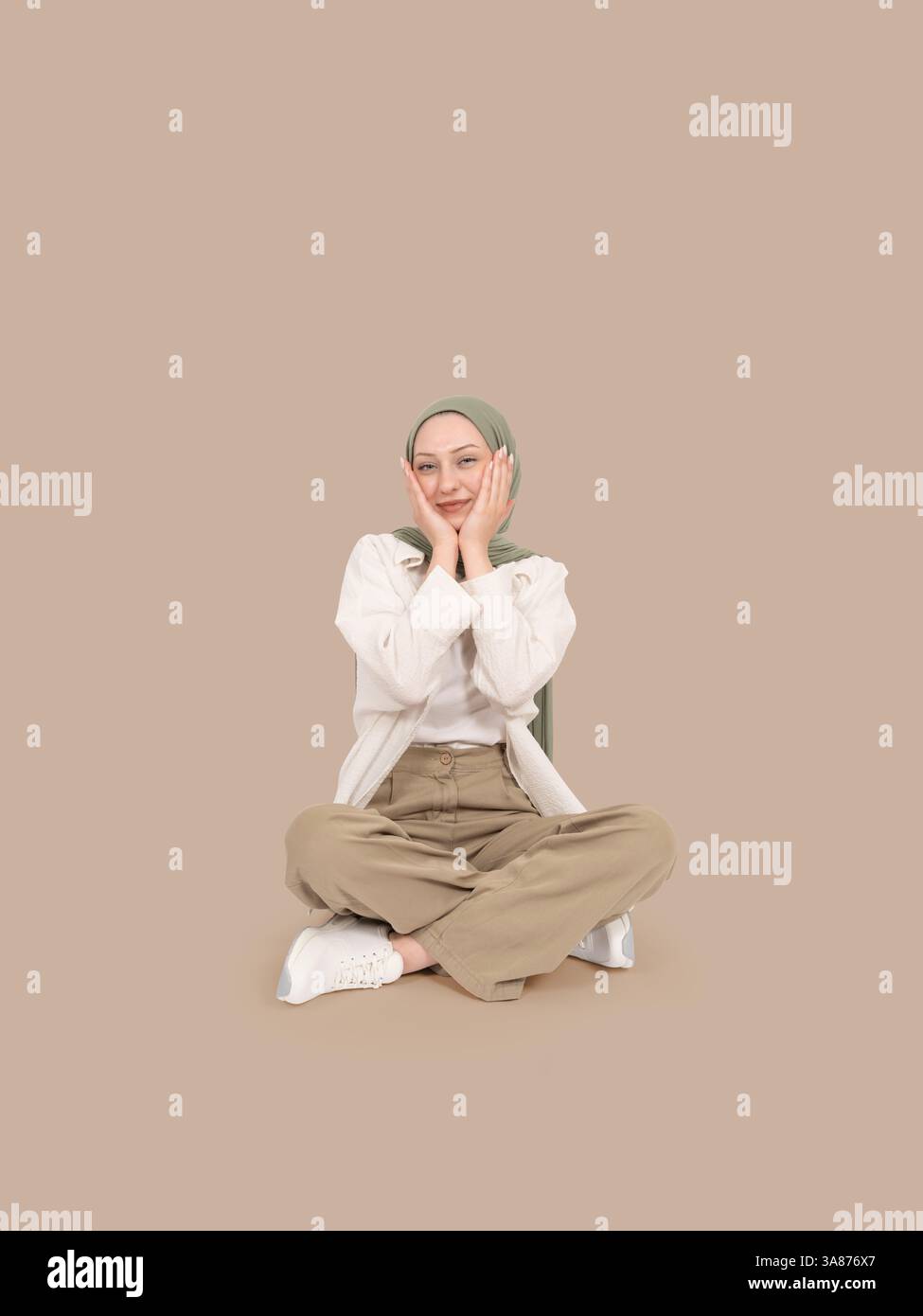 Shy looking beautiful muslim woman sit floor legs crossed wear hijab ...