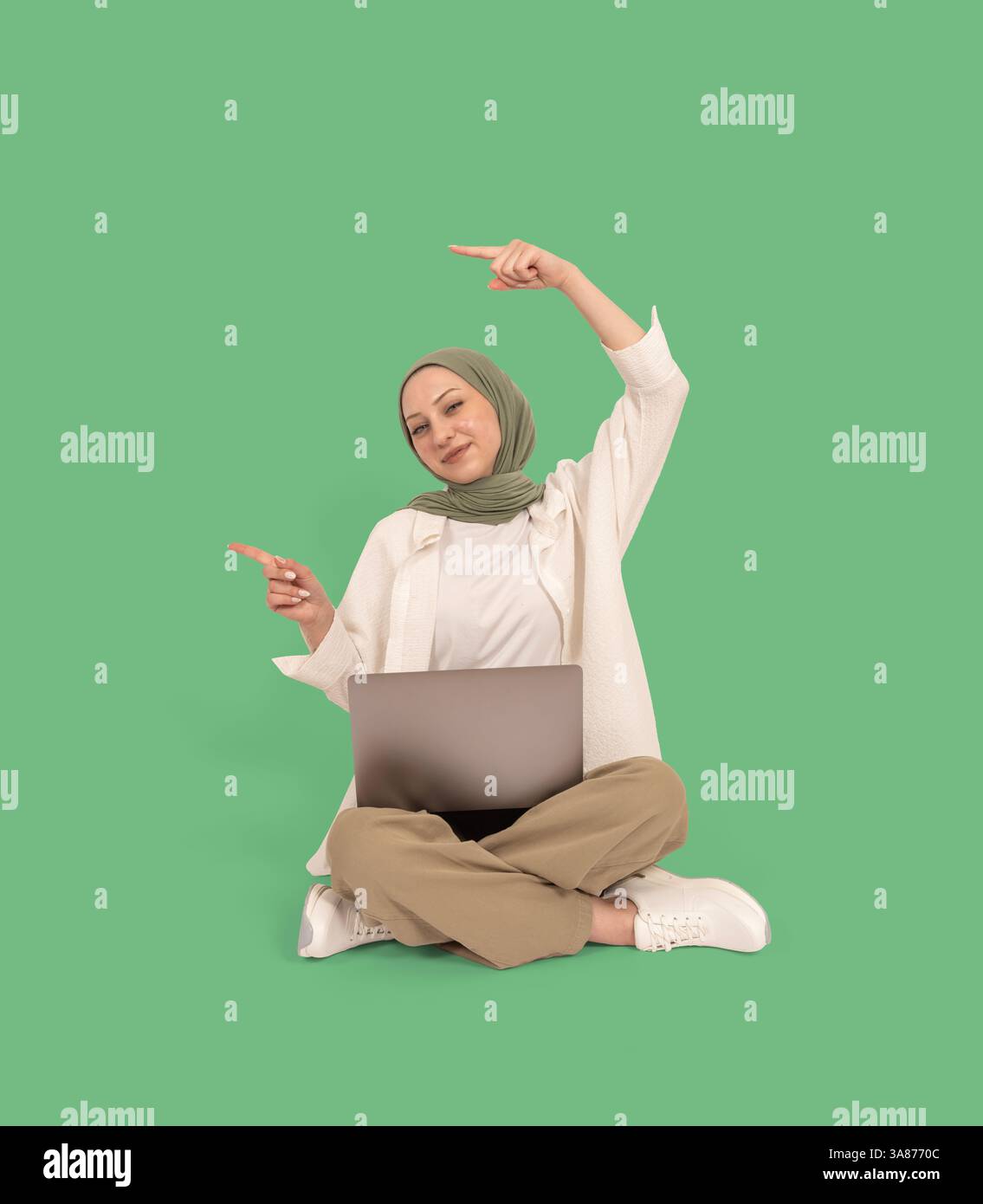 Sit on floor legs crossed. Holding open notebook pc computer on her lap ...