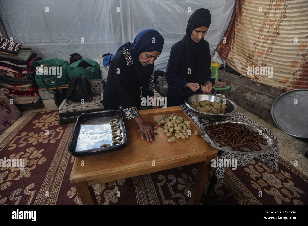 A Palestinian family prepares traditional cookies in preparation for ...
