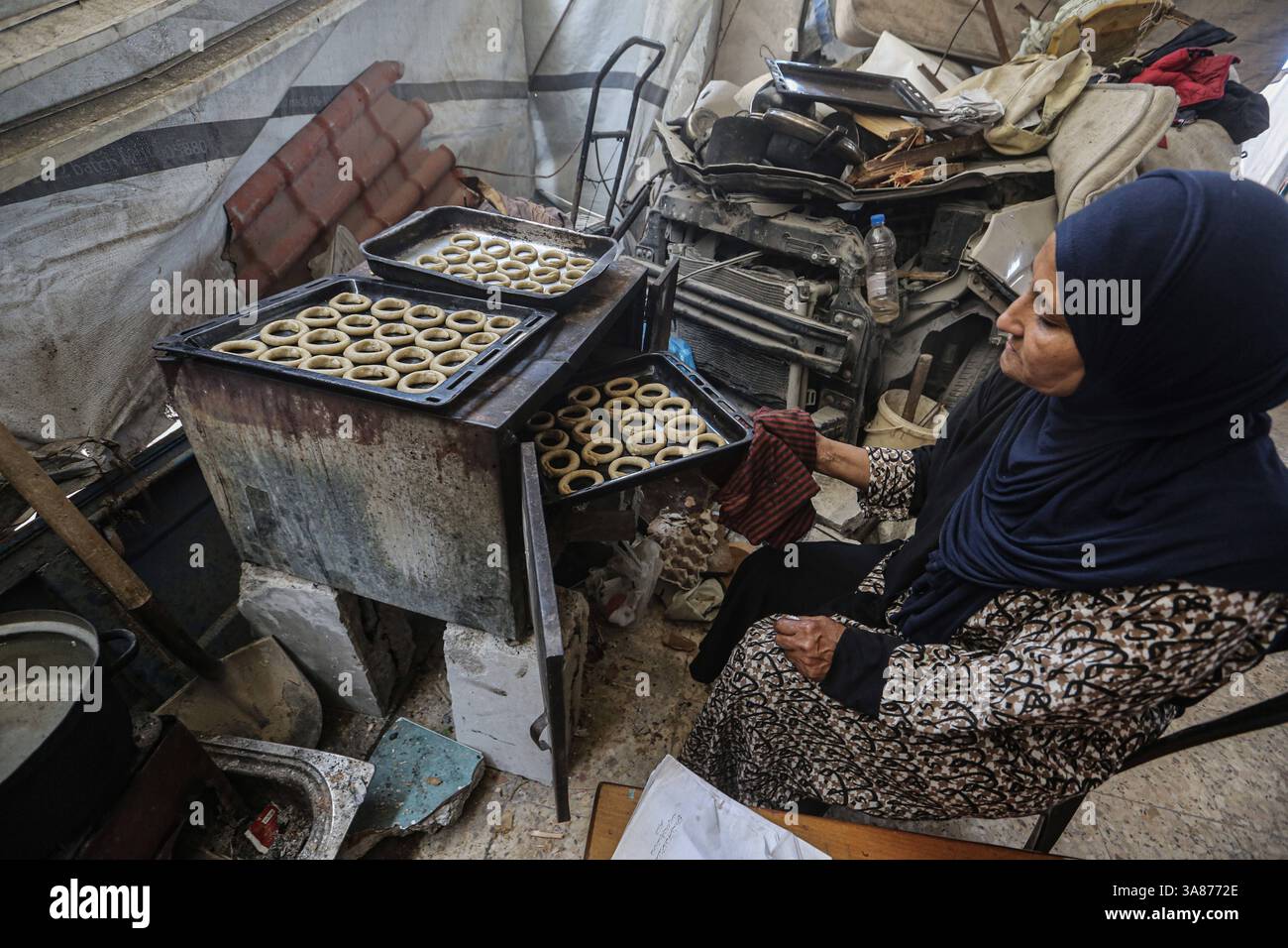 A Palestinian family prepares traditional cookies in preparation for ...