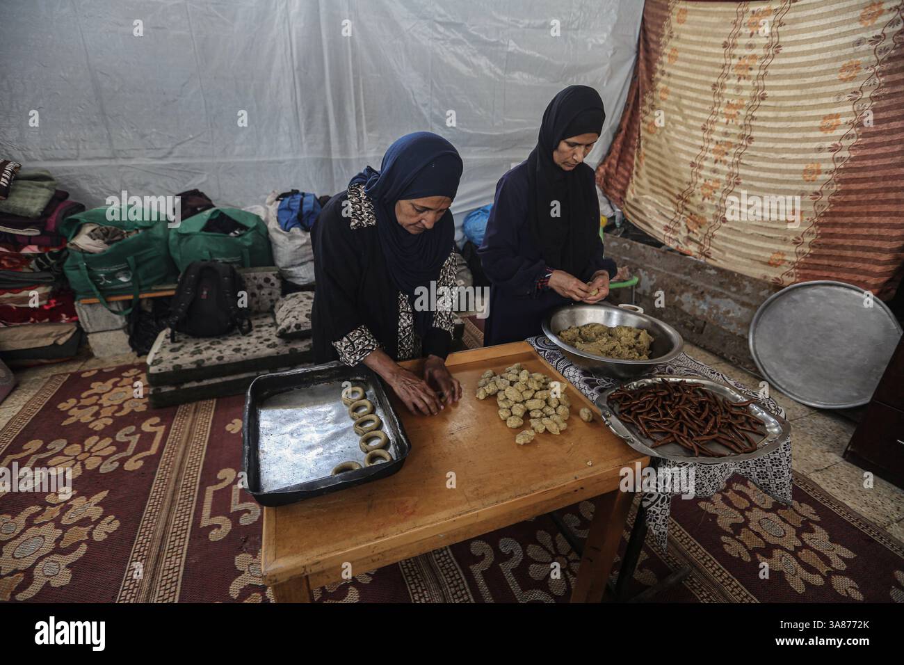 A Palestinian family prepares traditional cookies in preparation for ...
