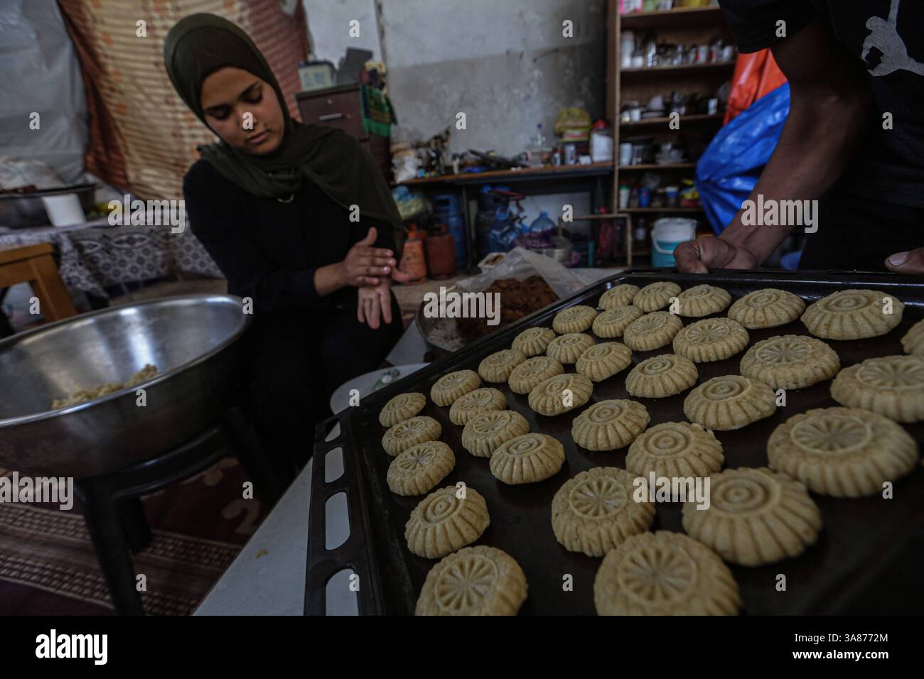 A Palestinian family prepares traditional cookies in preparation for ...