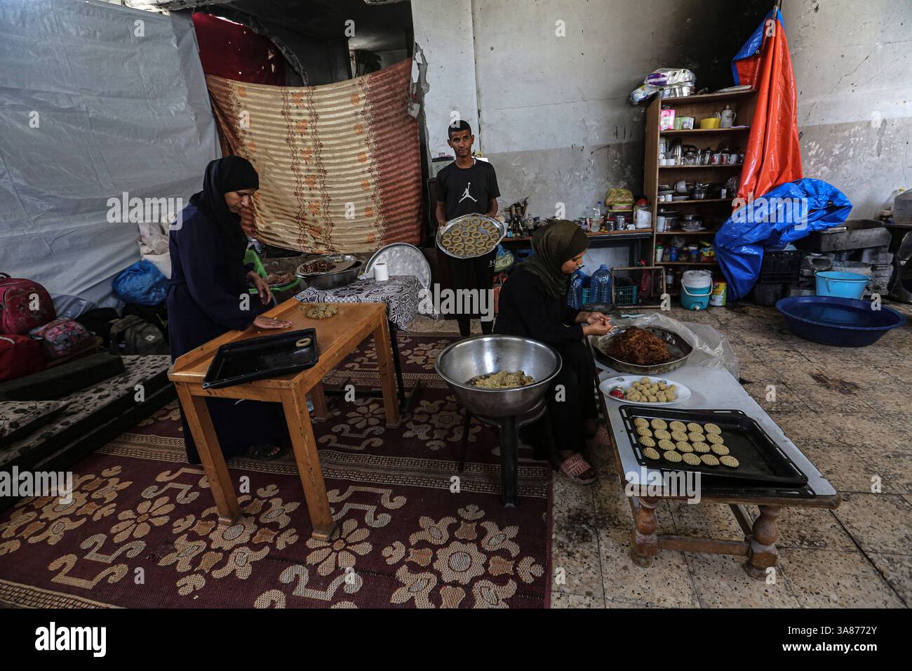 A Palestinian family prepares traditional cookies in preparation for ...