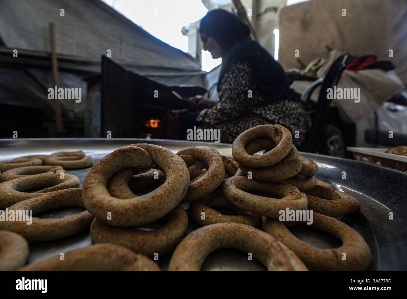 A Palestinian family prepares traditional cookies in preparation for ...