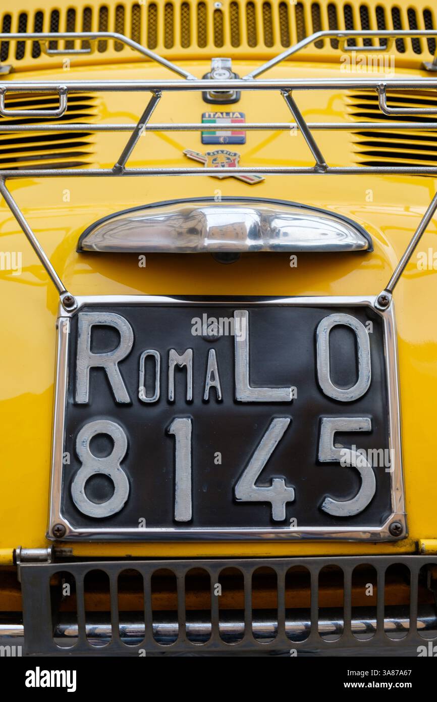 The rear detail of a classic yellow Italian car, possibly a Fiat 500 ...