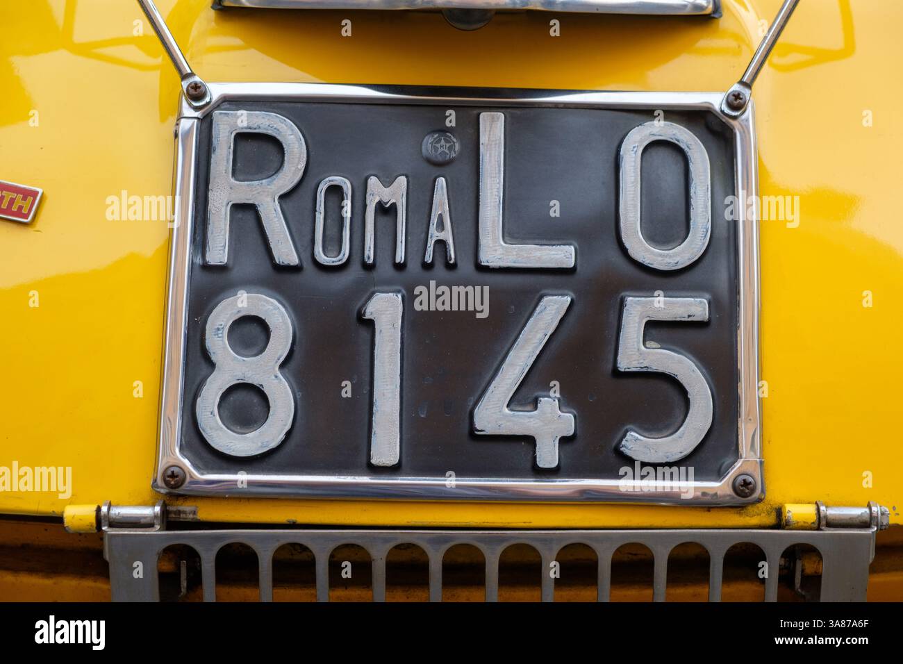 A vintage Italian license plate from Rome, reading "ROMA LO 8145," is ...