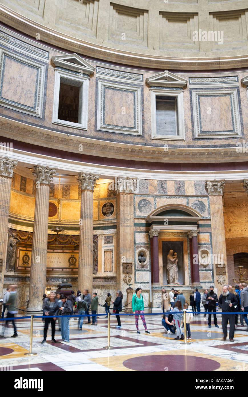 Tourists explore the grand interior rotunda of the Pantheon in Rome ...