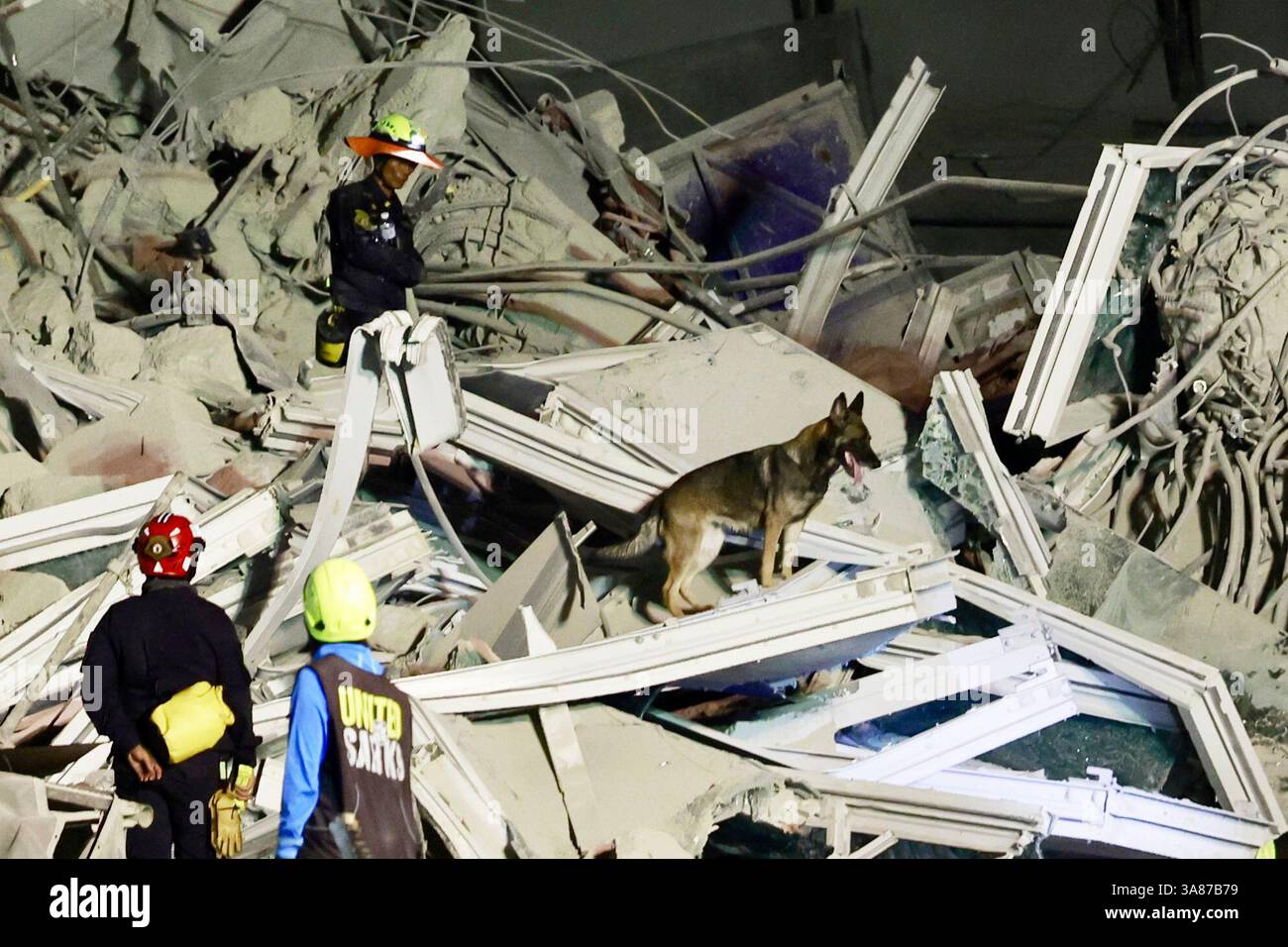 Rescuers work at the site a high-rise building under construction that ...
