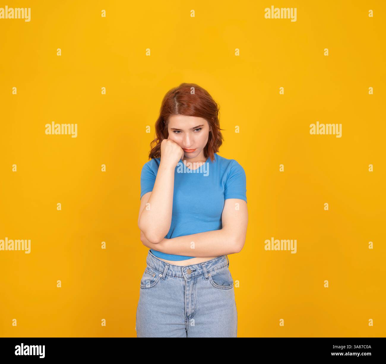 Sad depressed woman. Wearing casual shirt looking down prop up face ...