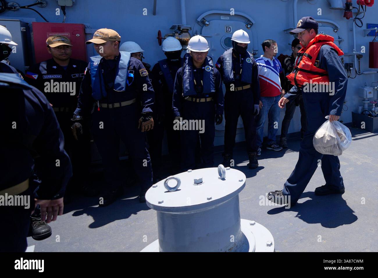 A US Navy personnel, right, prepares to be transferred by to USS Shoup ...