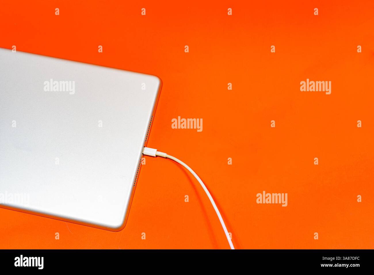 Modern device with connected USB cable on orange table Stock Photo - Alamy