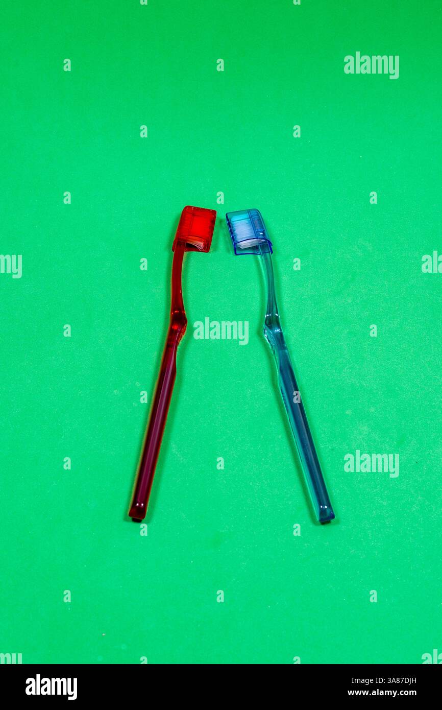 Red toothbrush and azun facing each other on a green surface Stock ...
