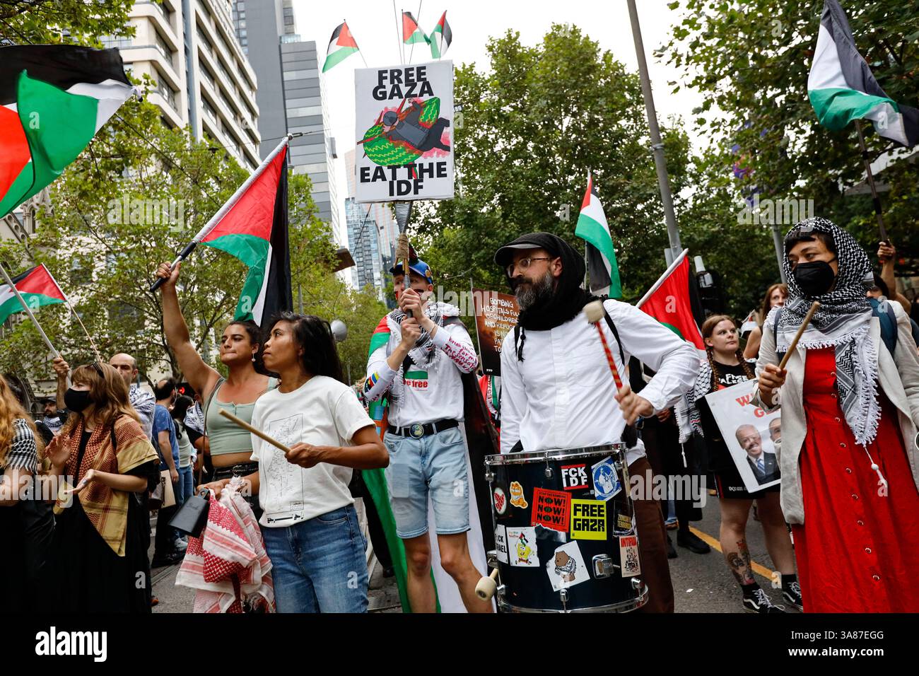 Marchers wave the Palestinian flag holding placards demanding the ...