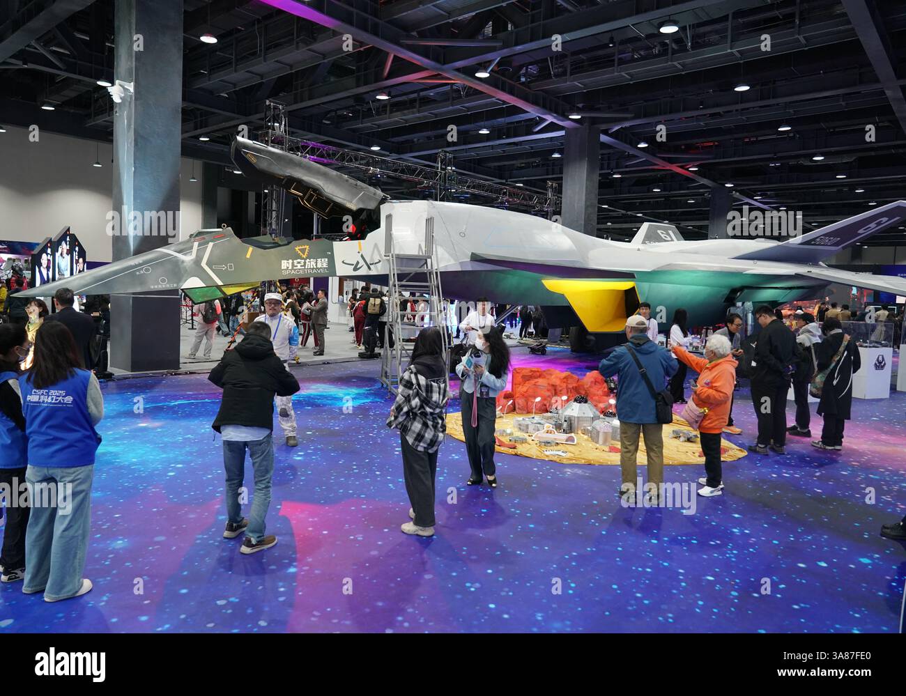 Beijing, China. 28th Mar, 2025. Visitors watch an aircraft model during a science fiction ...