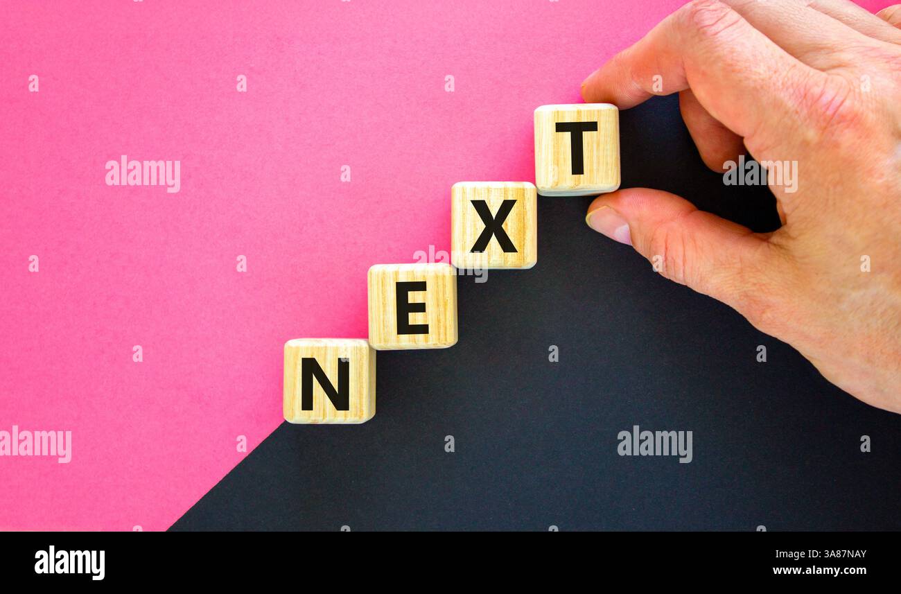 Next symbol. Concept word Next on beautiful wooden blocks. Businessman hand. Beautiful black and ...
