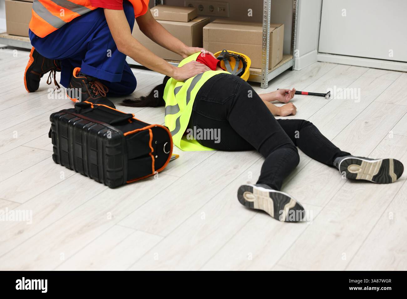Accident at work. Man helping his unconscious colleague in warehouse ...