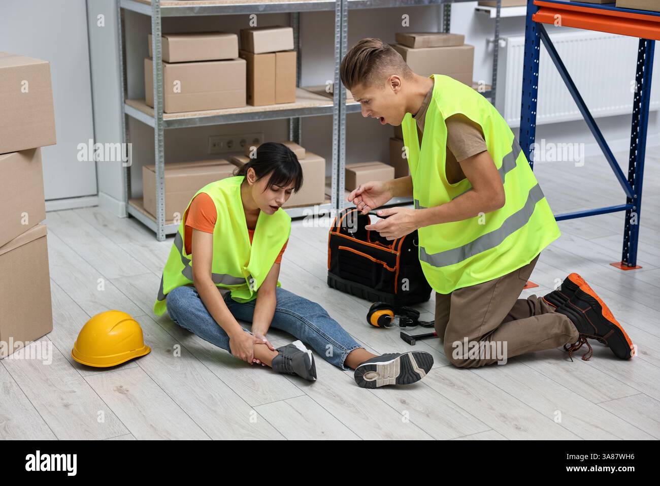 Accident at work. Man helping his injured colleague in warehouse Stock ...