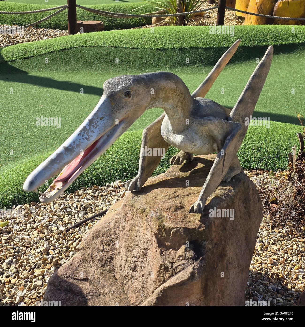A cute, retro winged pteranodon dinosaur sculpture at the mini golf at ...
