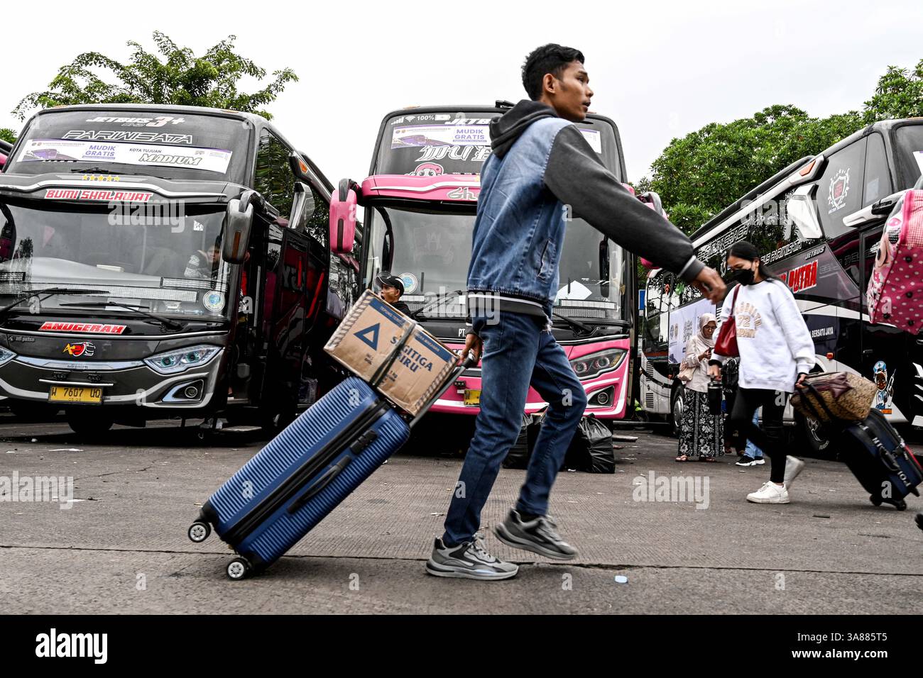 Tangerang, Indonesia. 28th Mar, 2025. A man prepares to board the bus ...