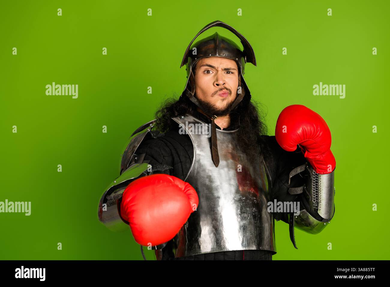 Funny medieval knight wearing boxing gloves posing on a green ...
