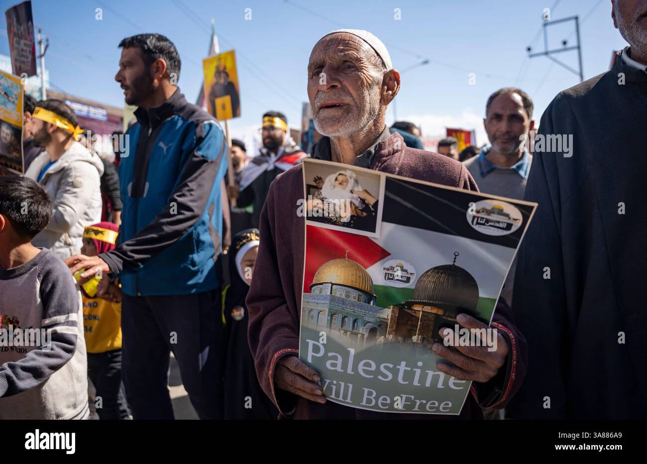 An old man walk with a placard during a rally marking Quds Day ...
