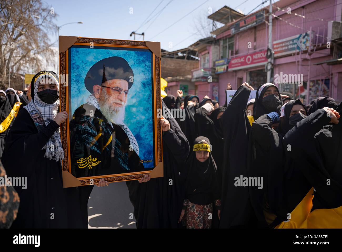 Muslim women hold a photo frame of Iranian leader Ayatollah Sayyed Ali ...
