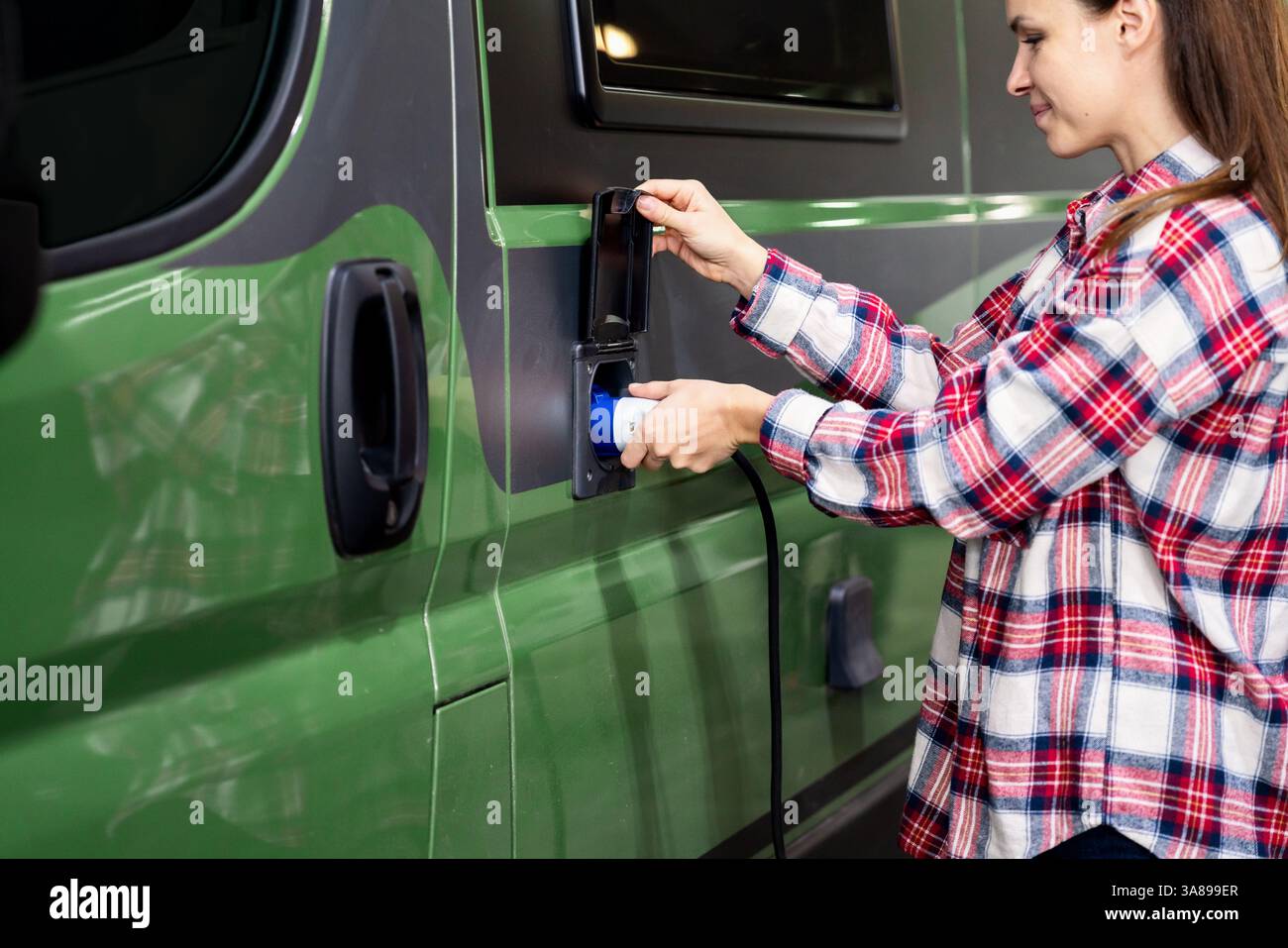 Woman connecting charging cable to power input port on Recreational ...