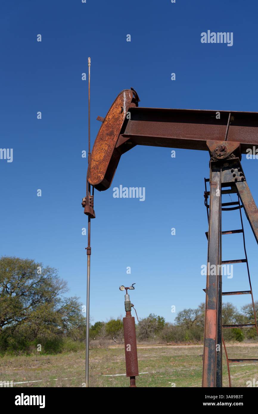 Idle, rusty oil well pump jack abandoned in field in West Texas Stock ...