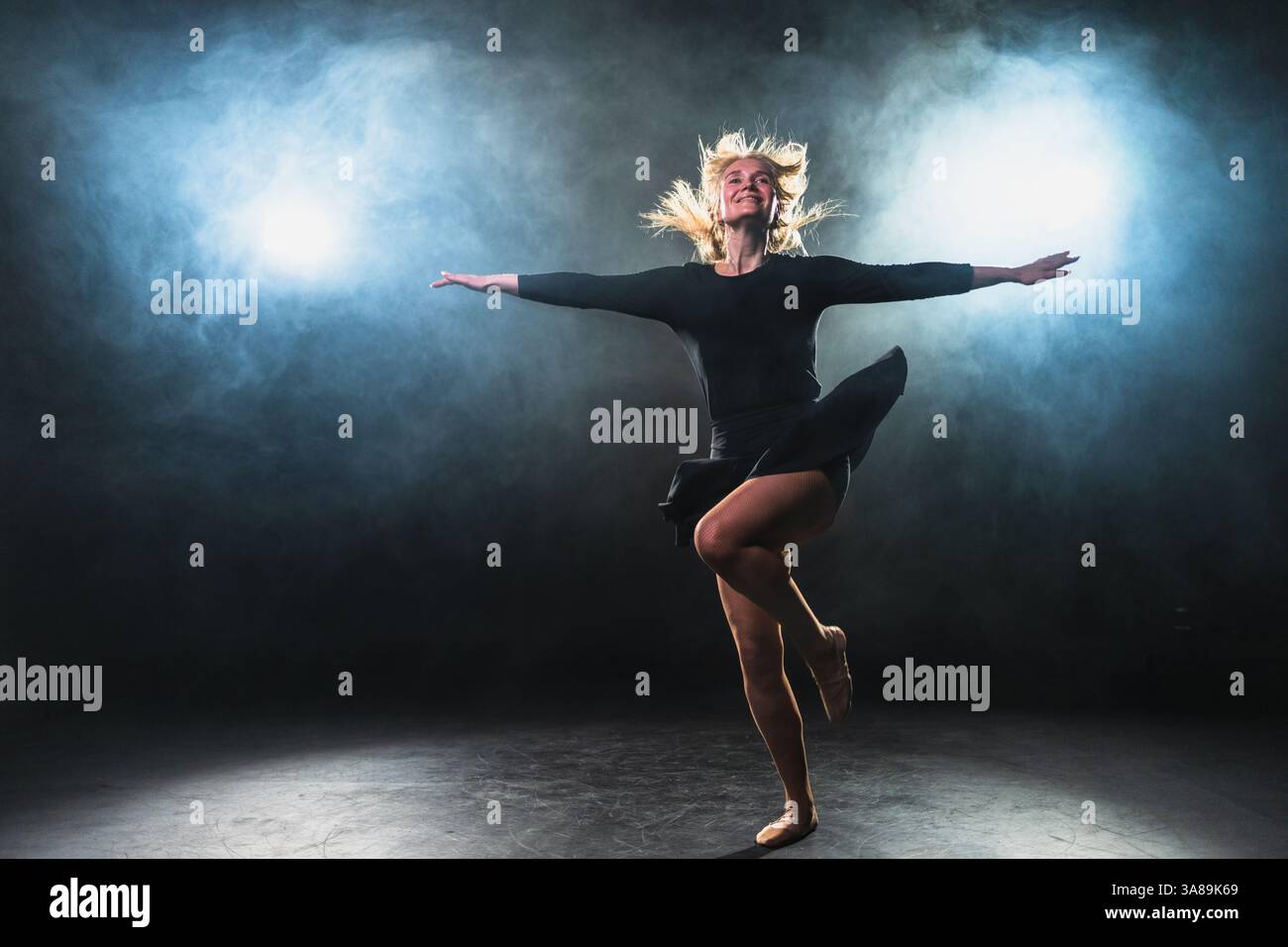 Contemporary woman dancer posing on black background with smoke. Adult ...