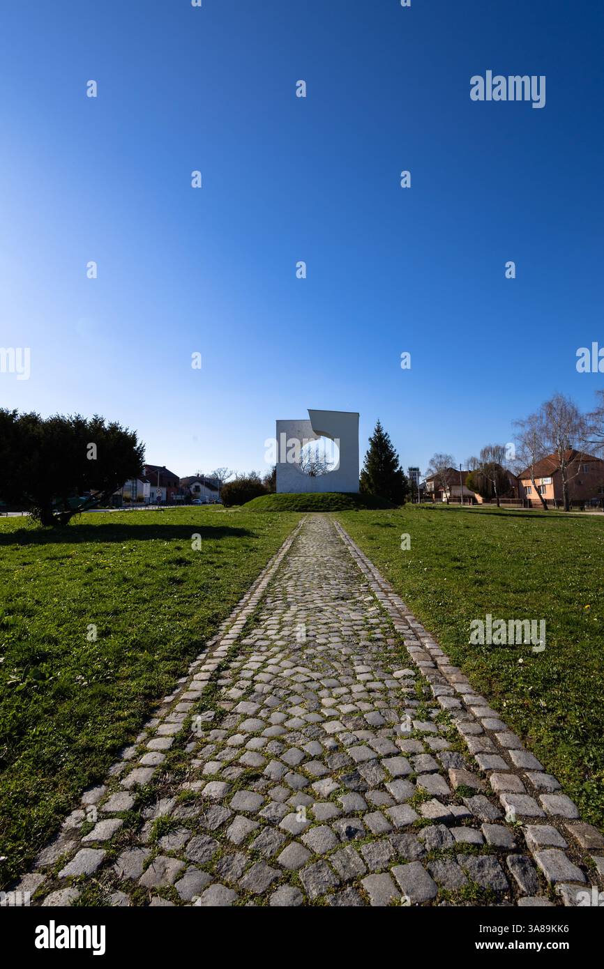 Modern white concrete monument featuring a circular design, set amid ...